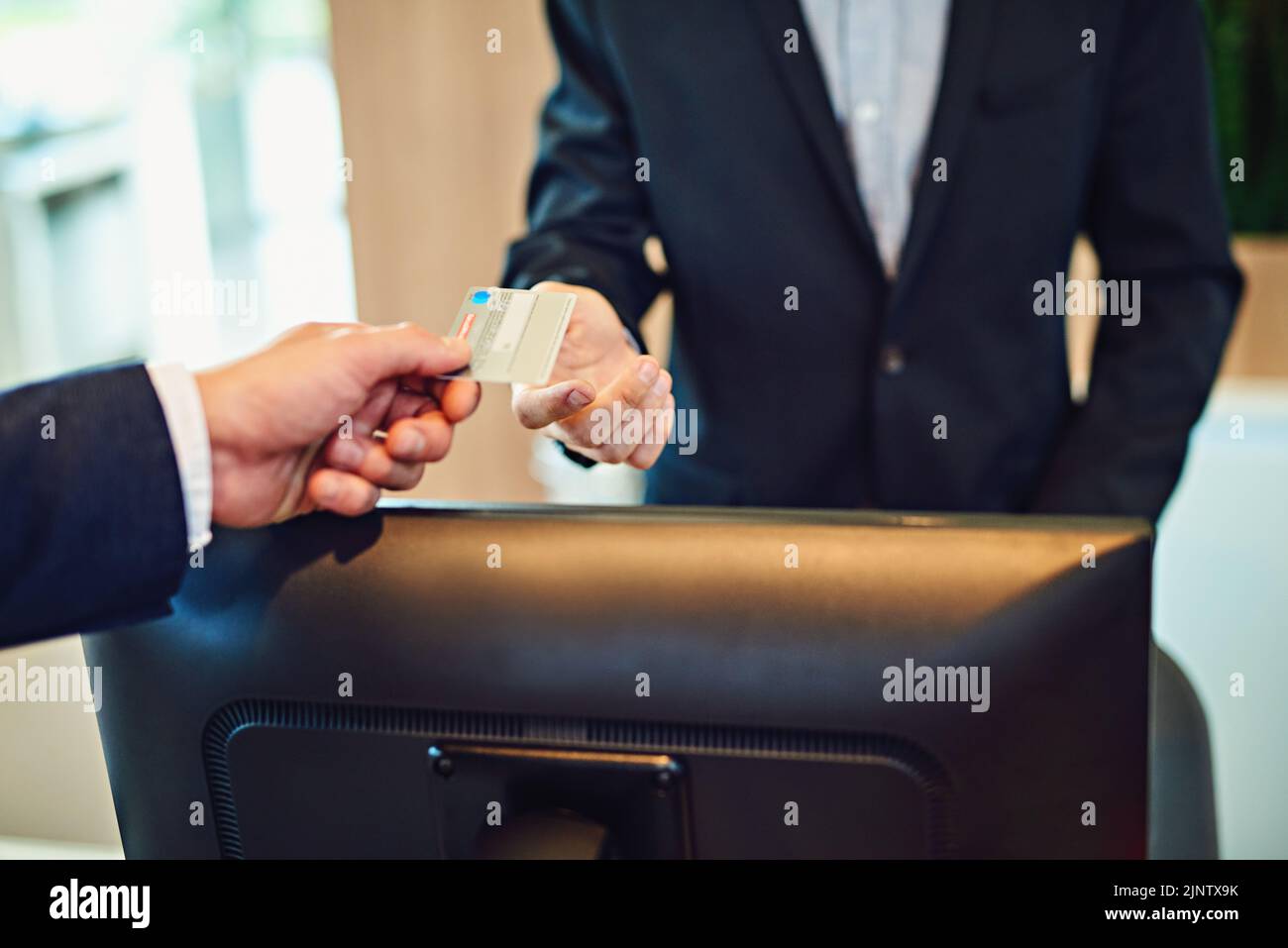 Paying for our booking. an unrecognizable businessman checking in and ...