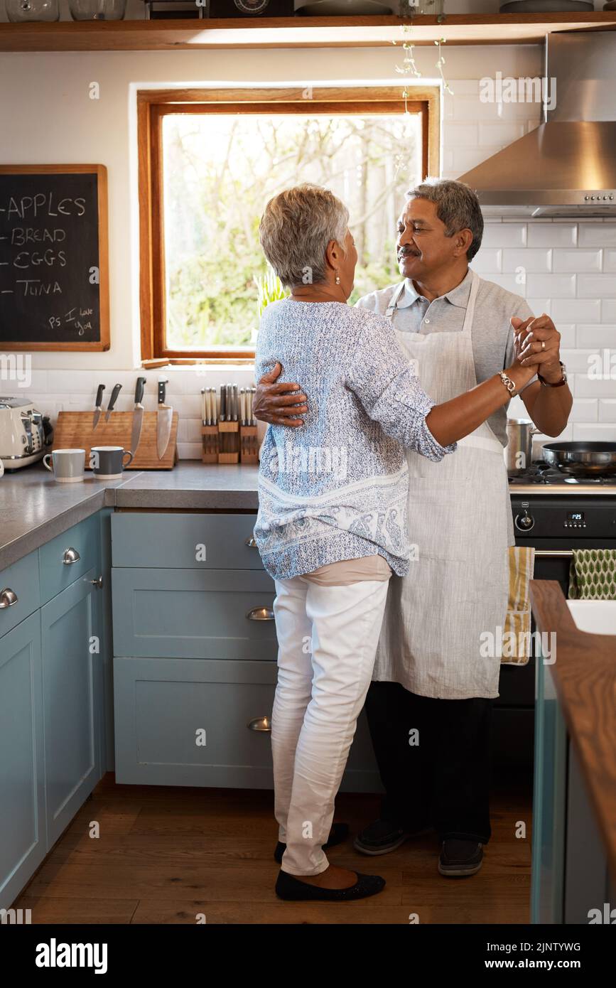 The kitchen is the unofficial dance floor. a happy mature couple ...