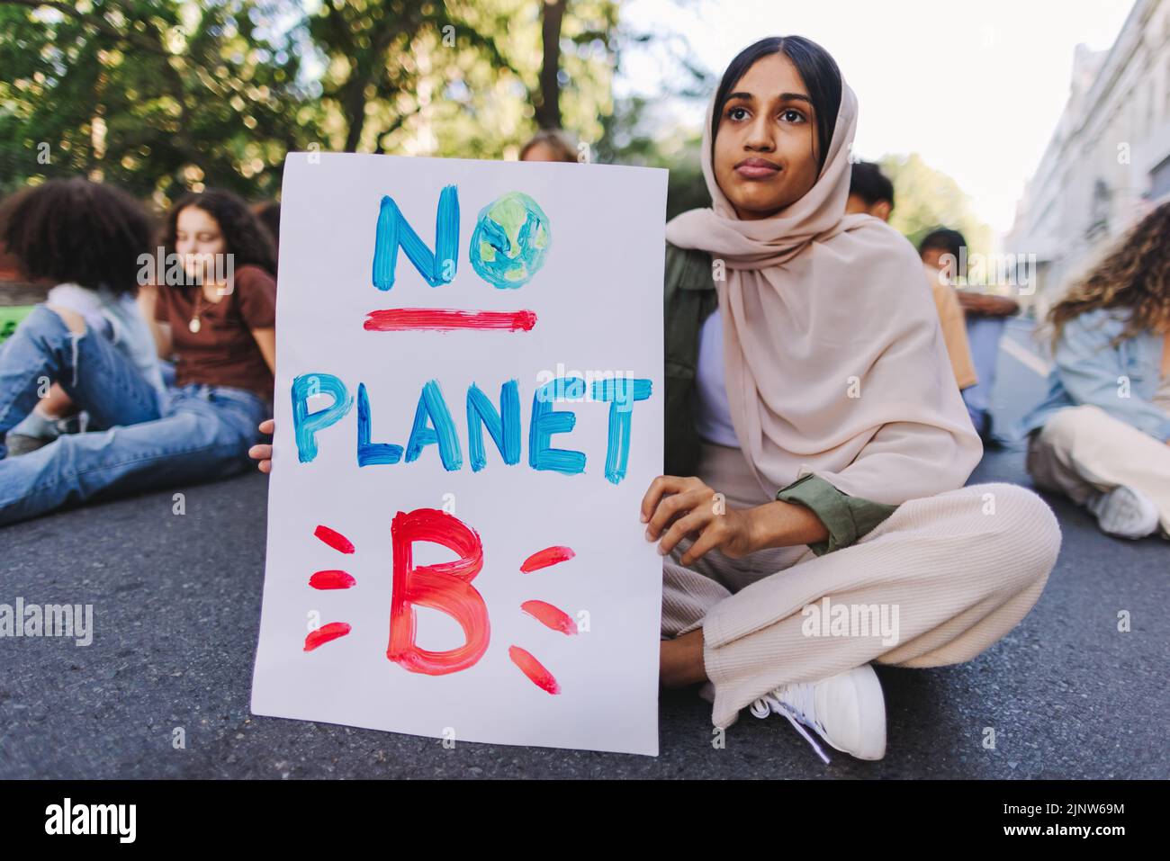 Muslim girl holding a "No planet B" poster at a climate change ...