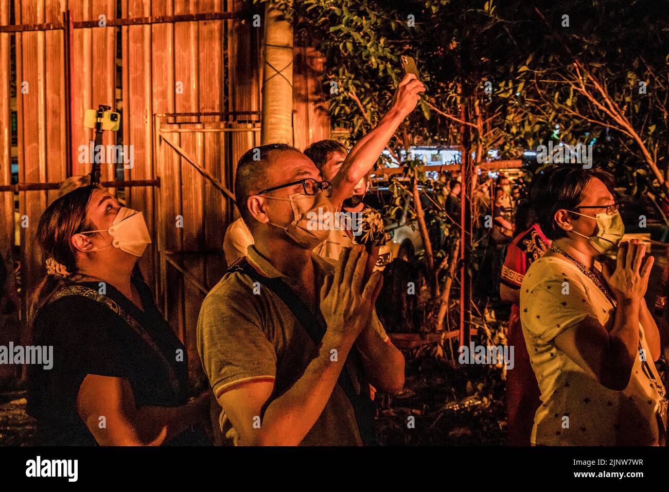 Malaysian Chinese people pray as they watch the giant paper statue of ...