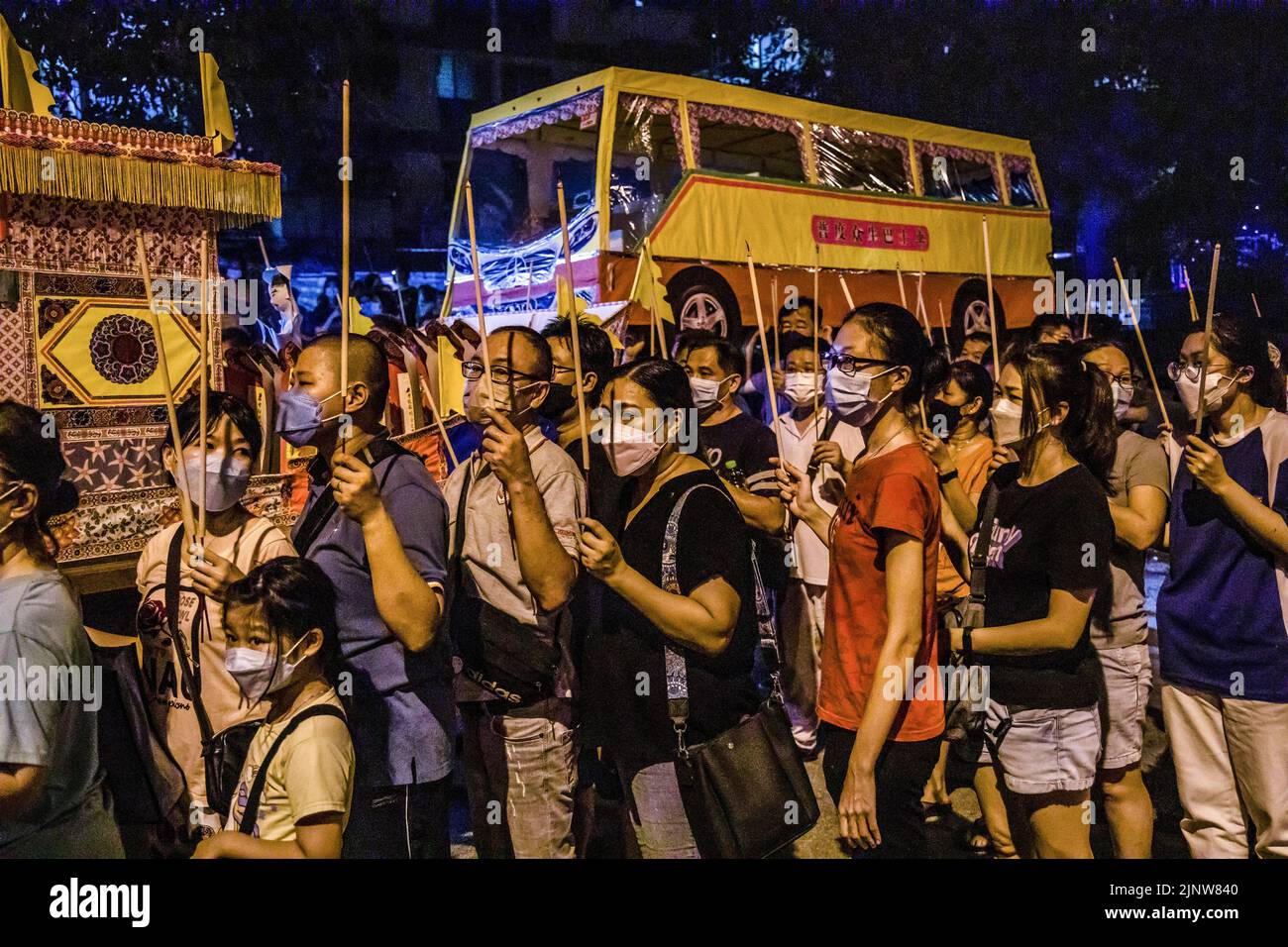 Malaysian Chinese people carry joss sticks in front of a paper bus during the Chinese Hungry ...