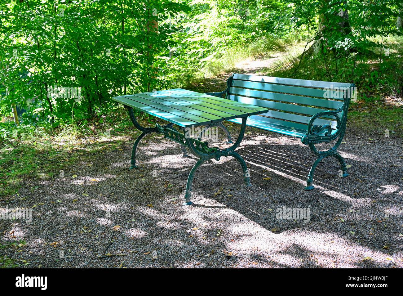 green bench standing in a shaded area in garden Stock Photo - Alamy