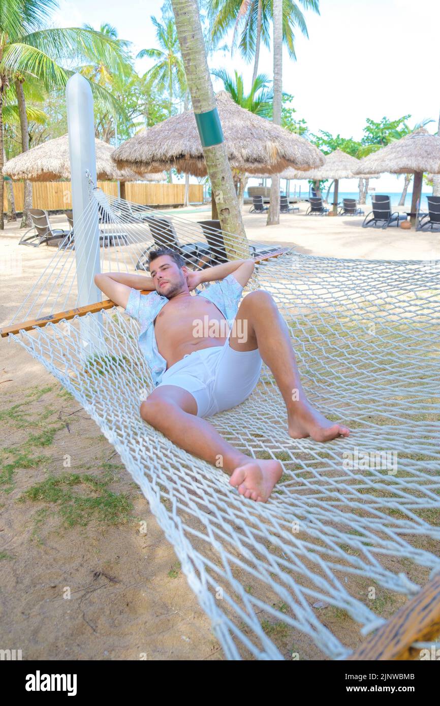 men relaxing in a hammock during a tropical heat wave global warming ...