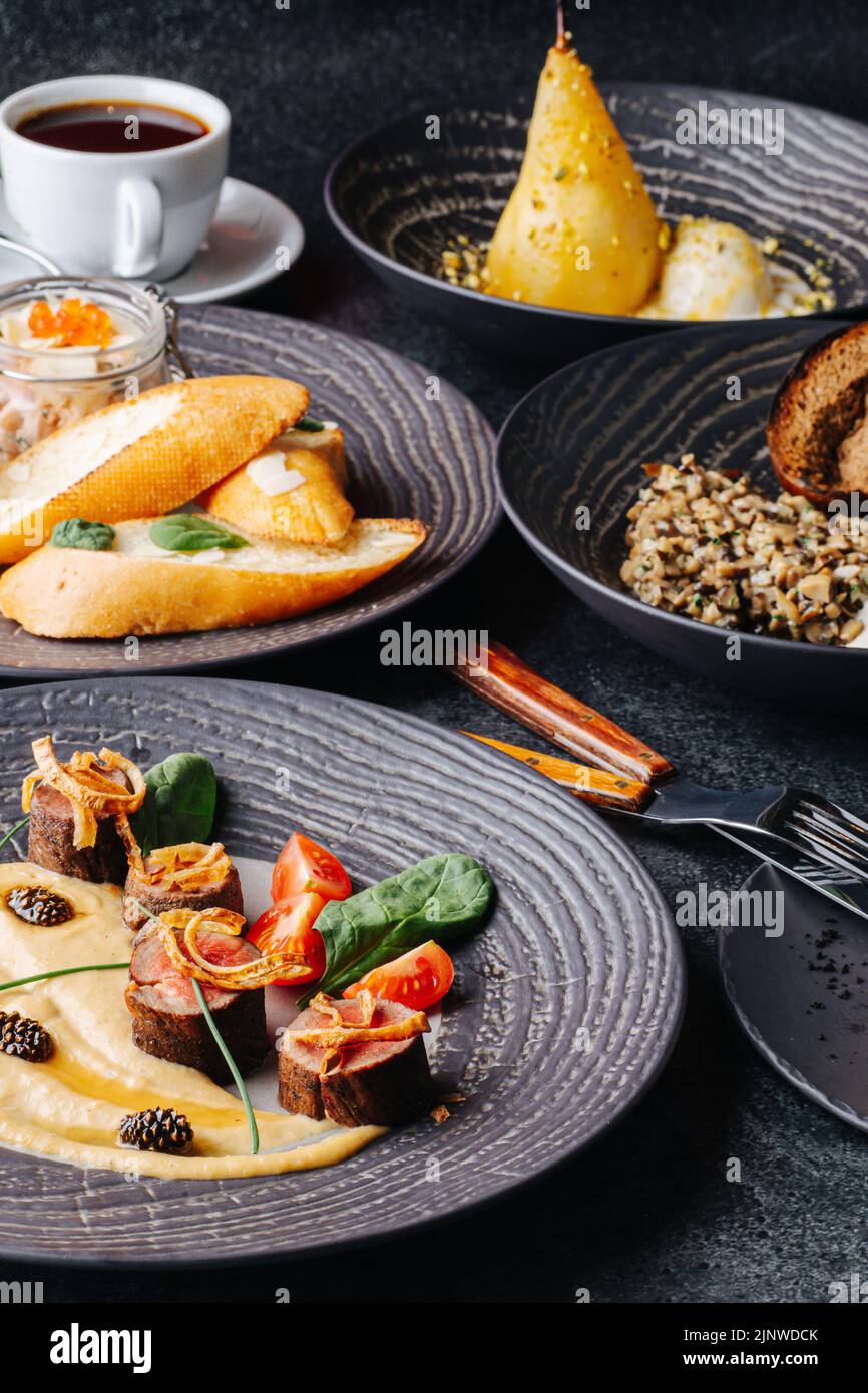 Low angle image of a dinner table full with exquisite dishes. Meat ...