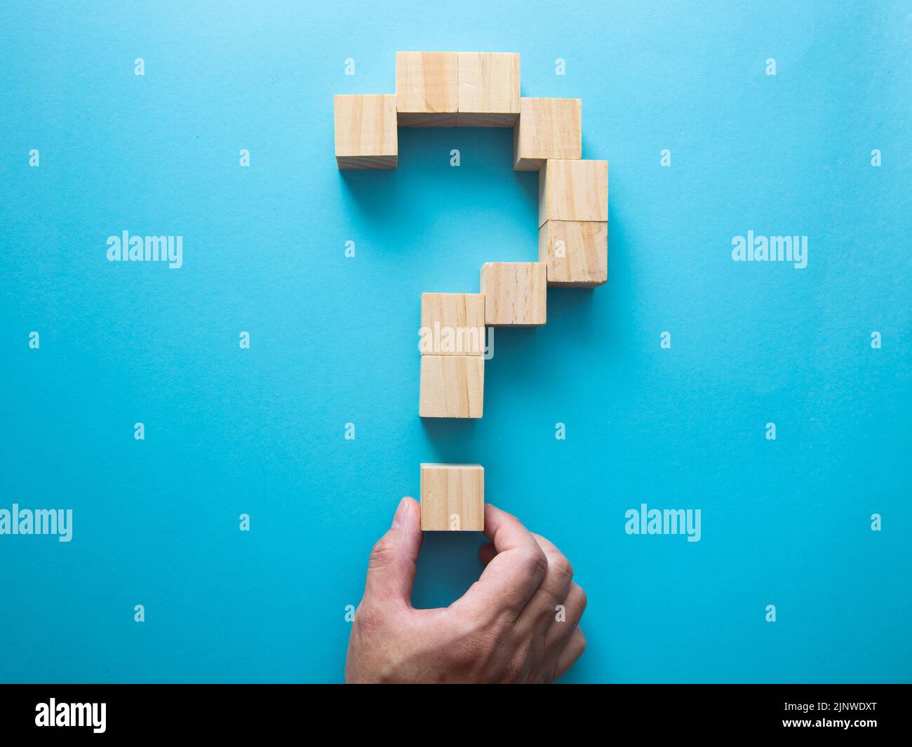 Hand forming a question marks symbol, financial business concept, blue ...