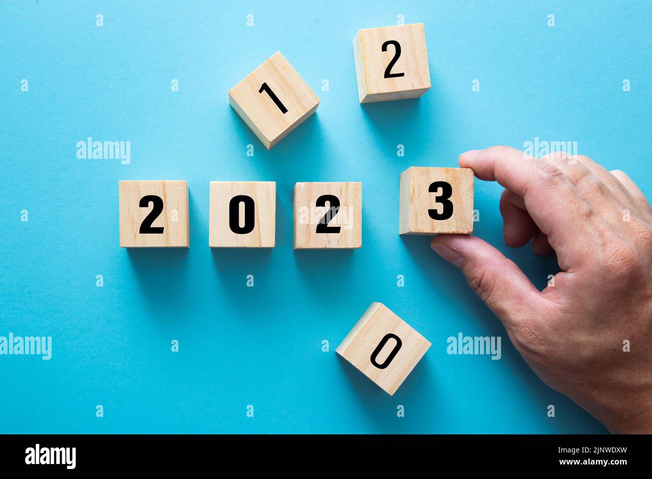 Hand making a 2023 on blue background for preparation new year change ...