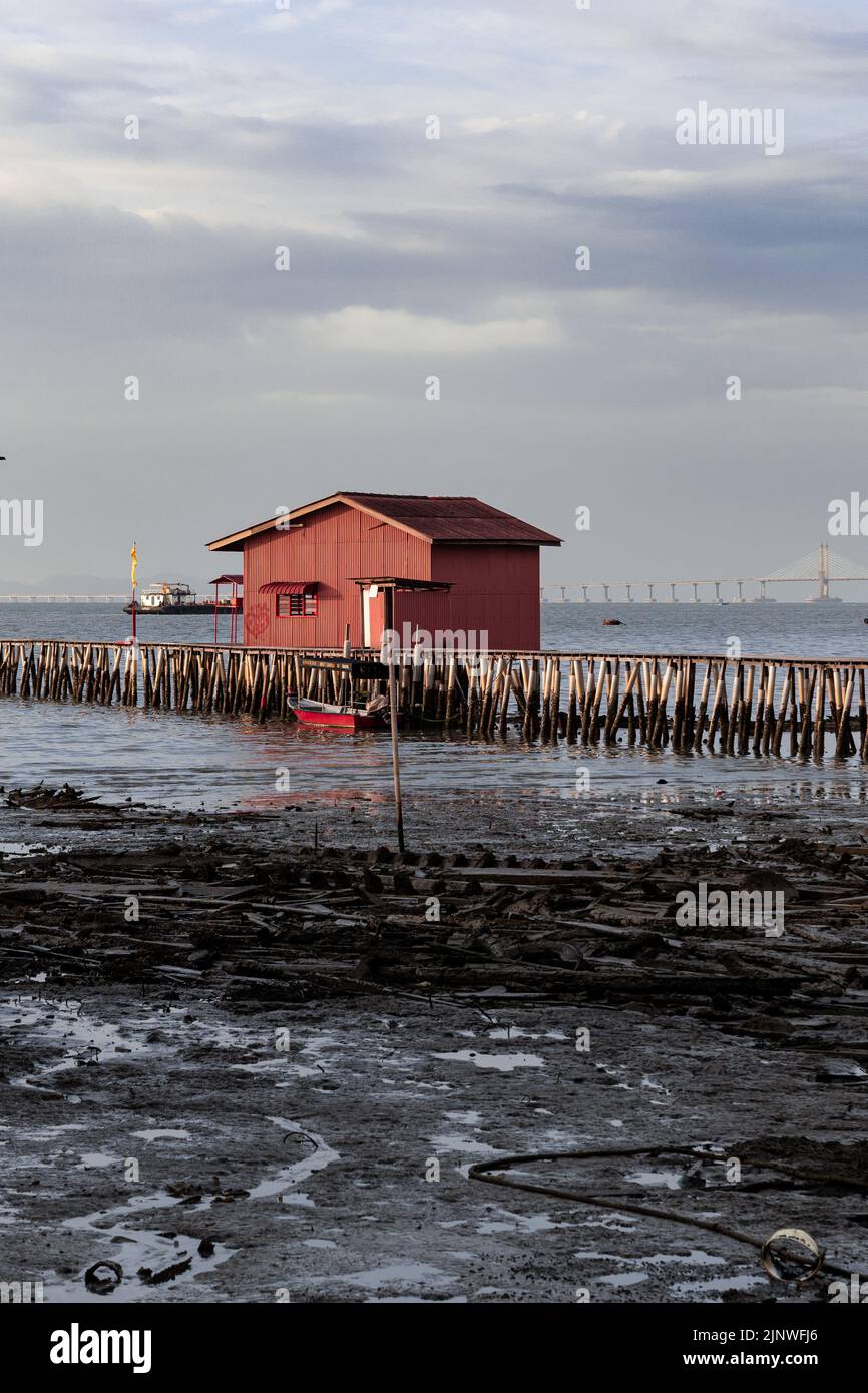 Sunrise view of wooden bridge and red house background at Clan Tan Jetty, one of tourist spots ...