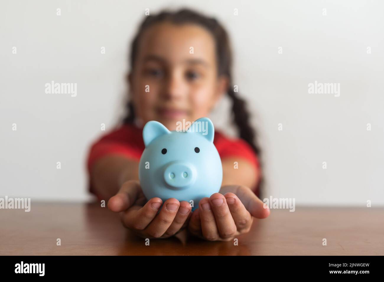 Little girl saving money in a piggybank over a white background Stock ...