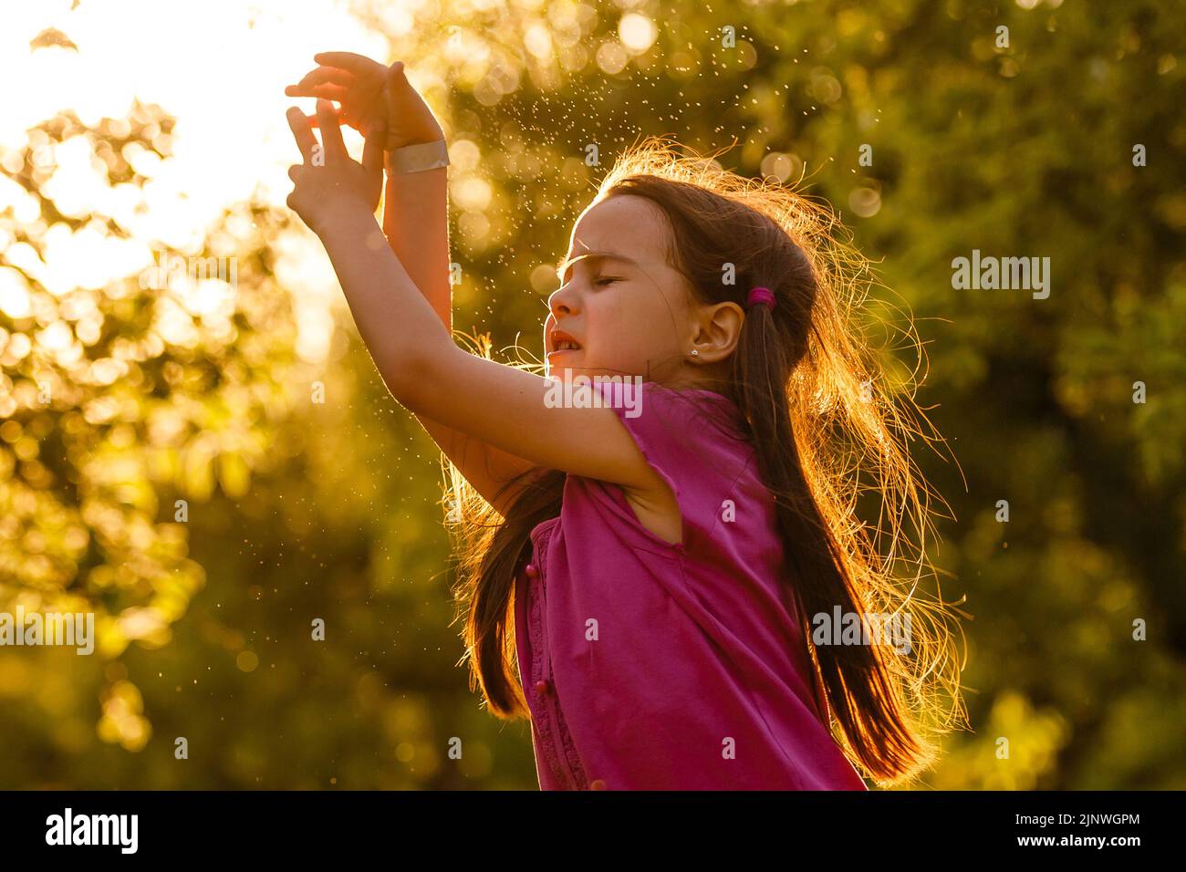Sweet child child trying to catch soap bubble Stock Photo - Alamy