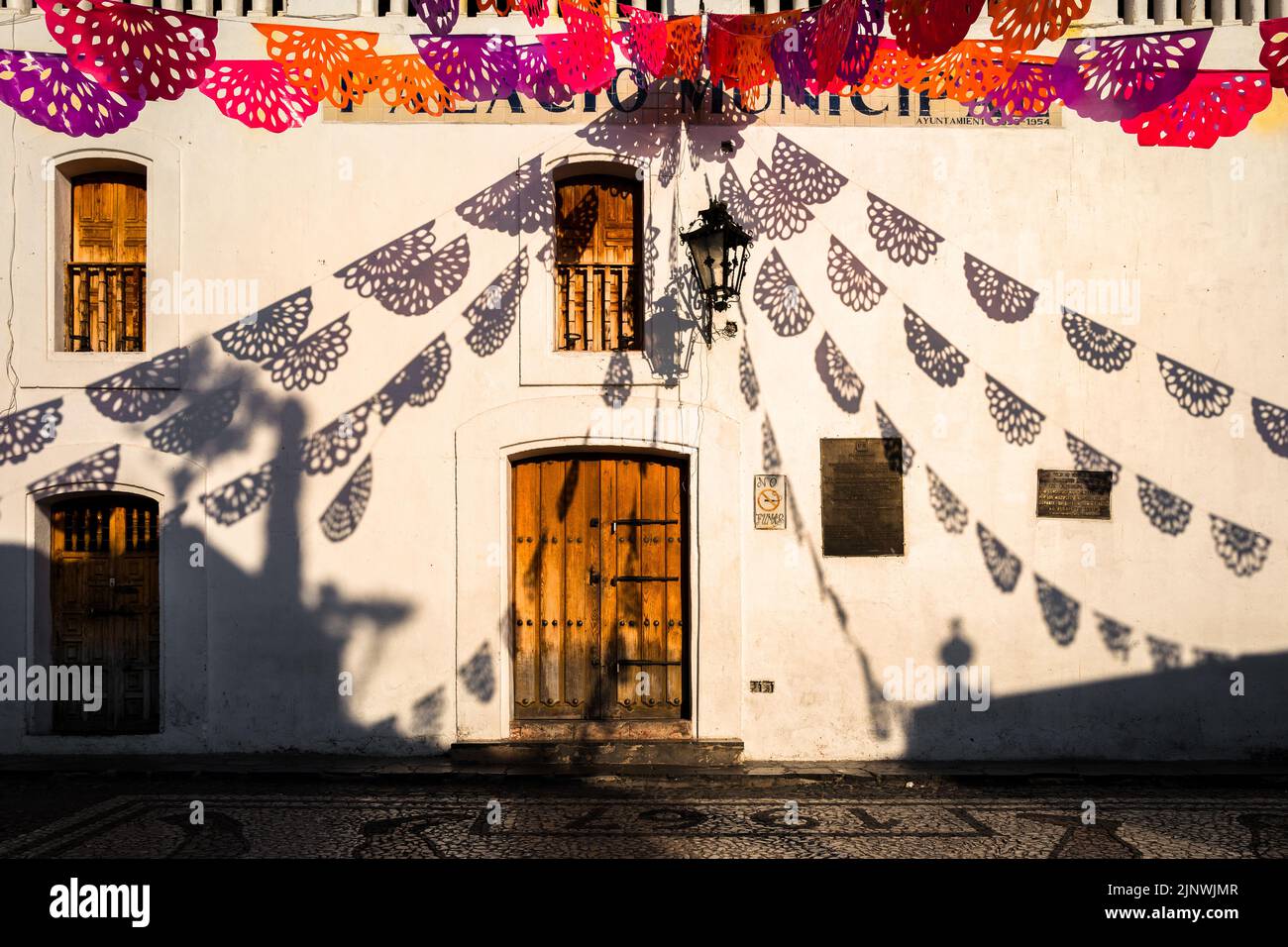 Pecked paper flags are hung over a colonial building during the Day of ...