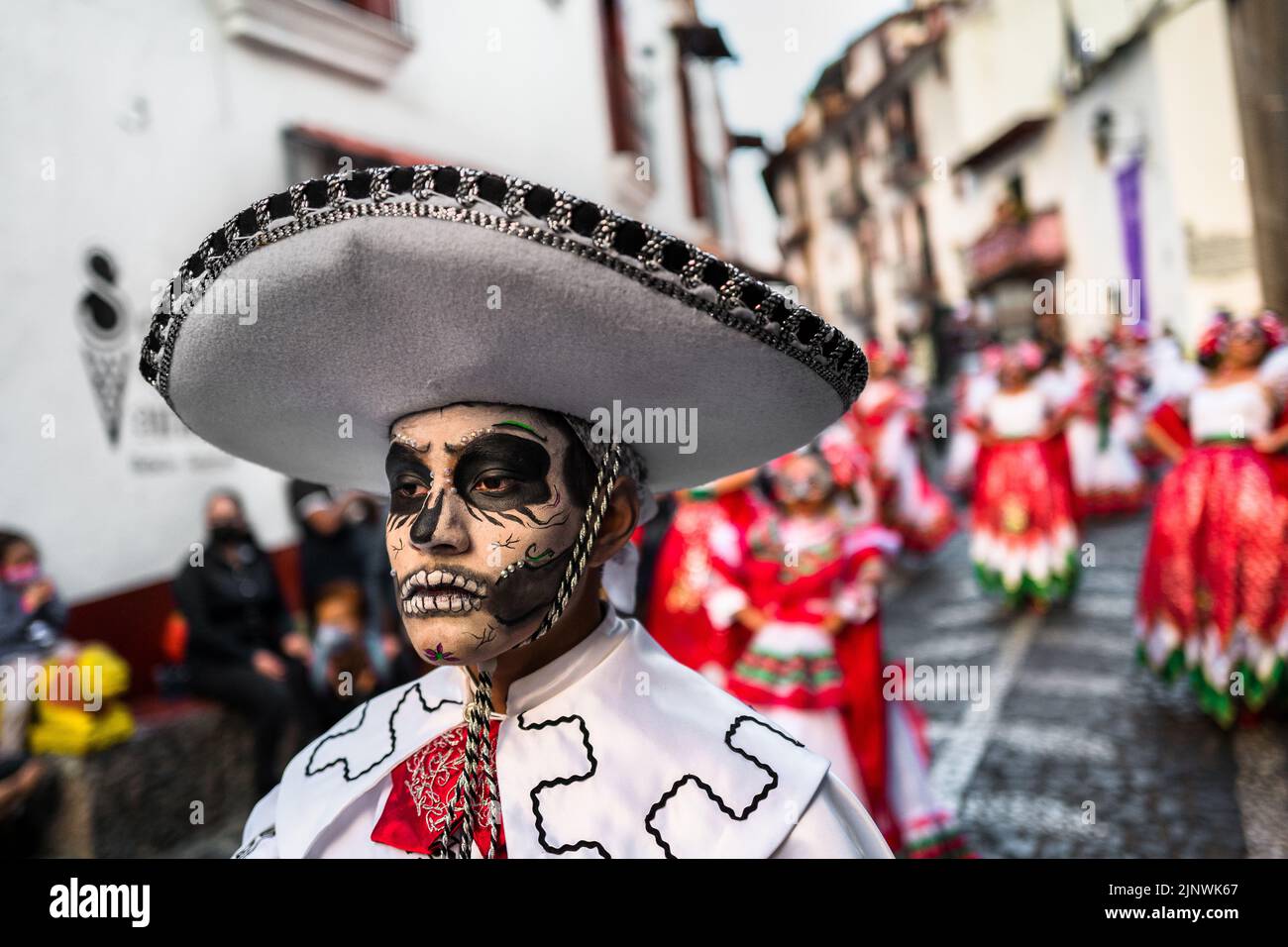 A Mexican man, with a face painted as Catrin and wearing a Mariachi ...