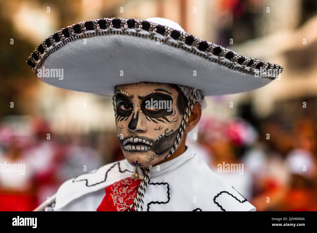 A Mexican man, with a face painted as Catrin and wearing a Mariachi ...