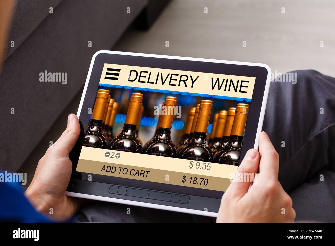 Person holding tablet and buying wine online Stock Photo - Alamy