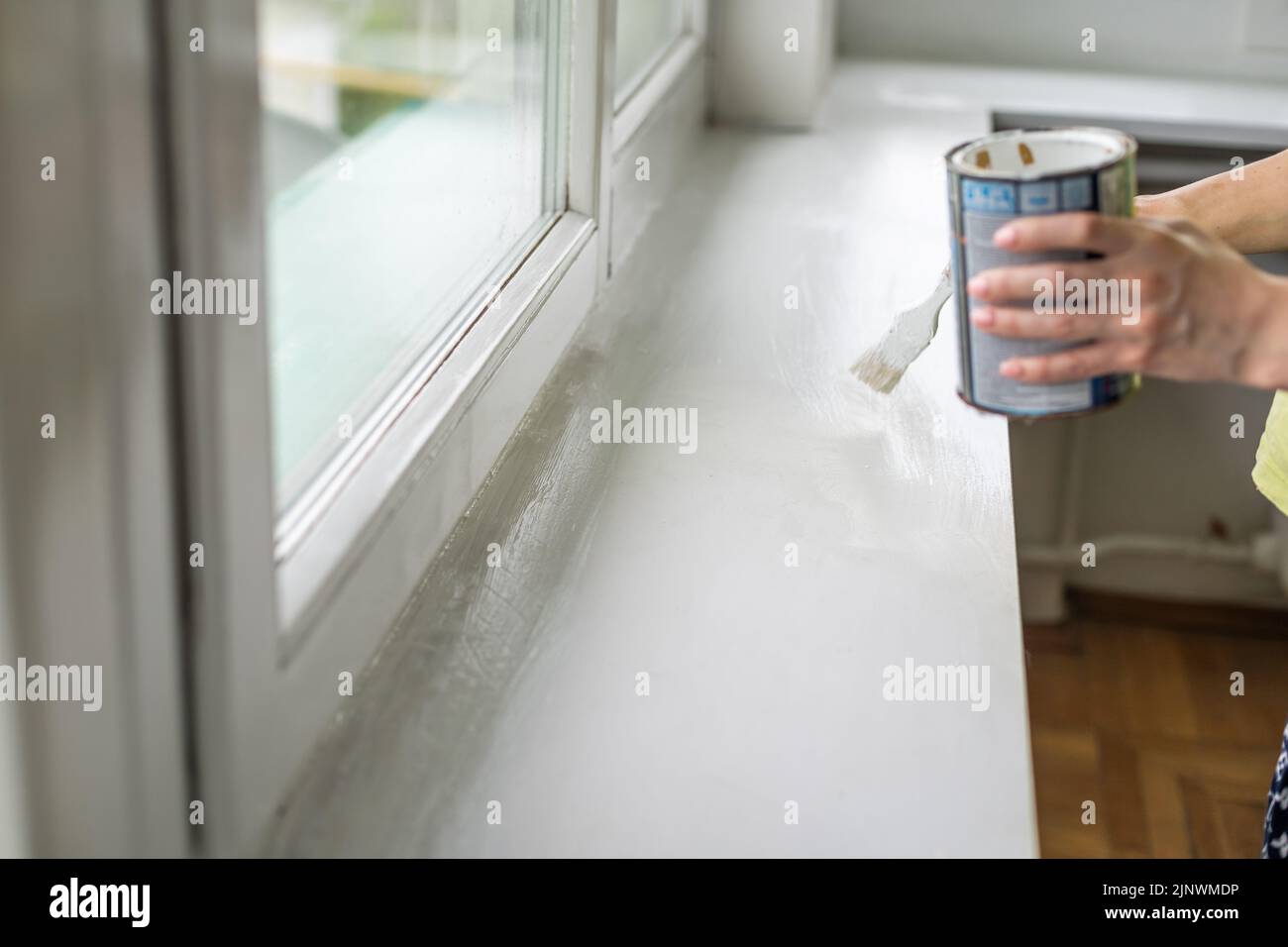 Worker painting frame of old window, painting old windows in white ...