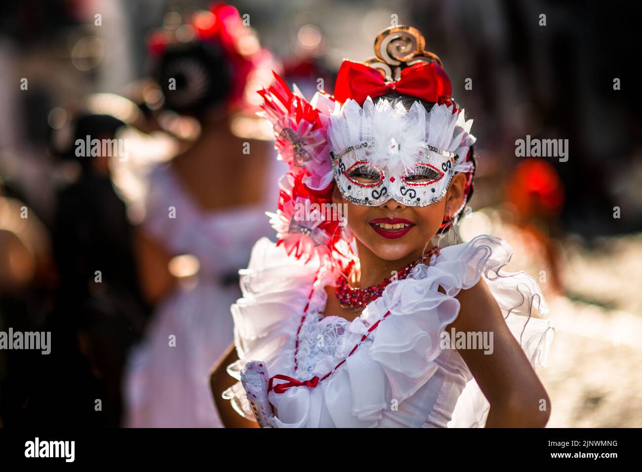 A Mexican girl, wearing a white domino mask, takes part in the Day of ...