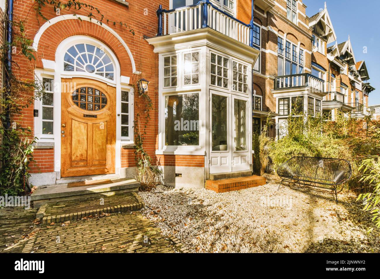 The front view of a brick building with signs,pavement and wooden doors ...