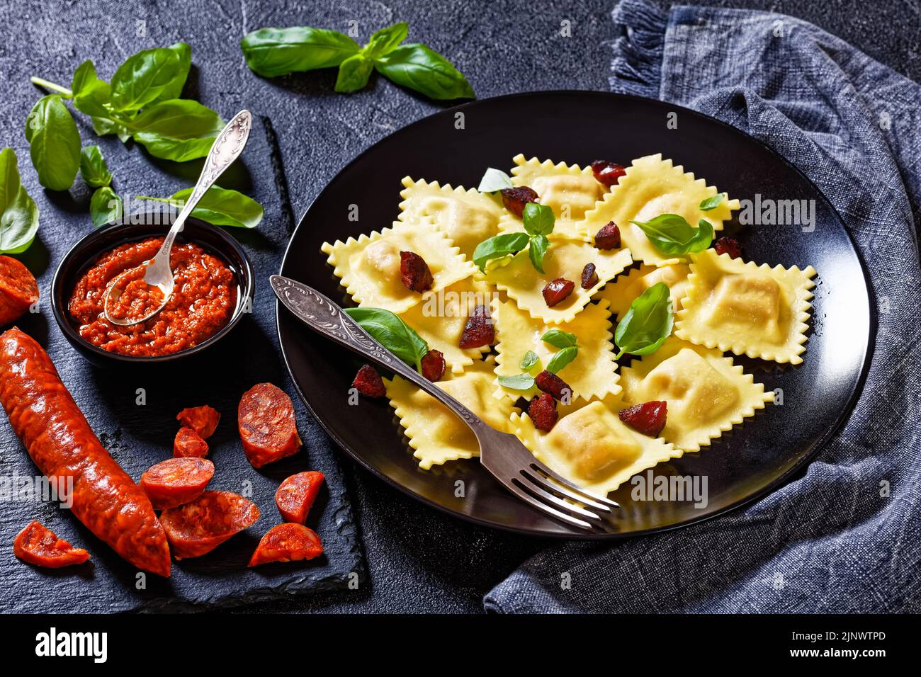 italian ravioli with chorizo ricotta filling served on black plate with ...