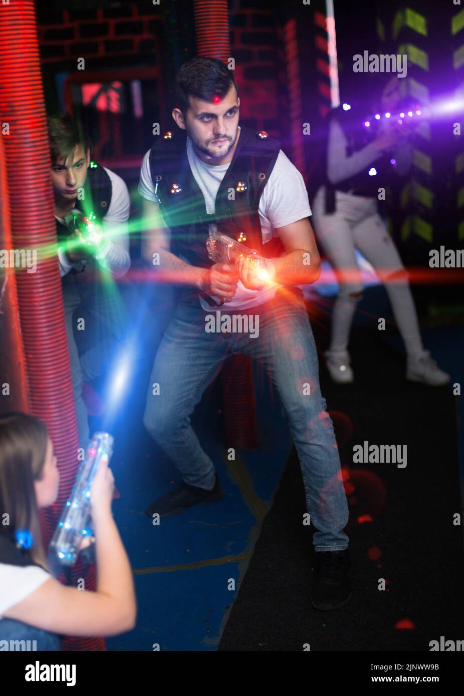Guy in colored beams during laser tag game Stock Photo - Alamy