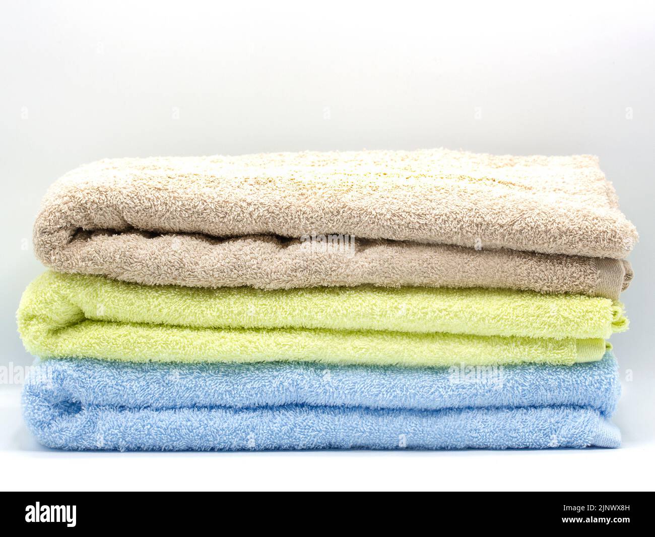 three color towels isolated on white background Stock Photo - Alamy