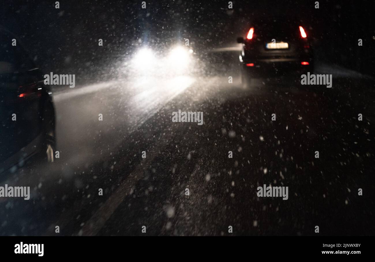 Warsaw, Poland - November 30, 2021: Snow at night on the road. Wet road ...