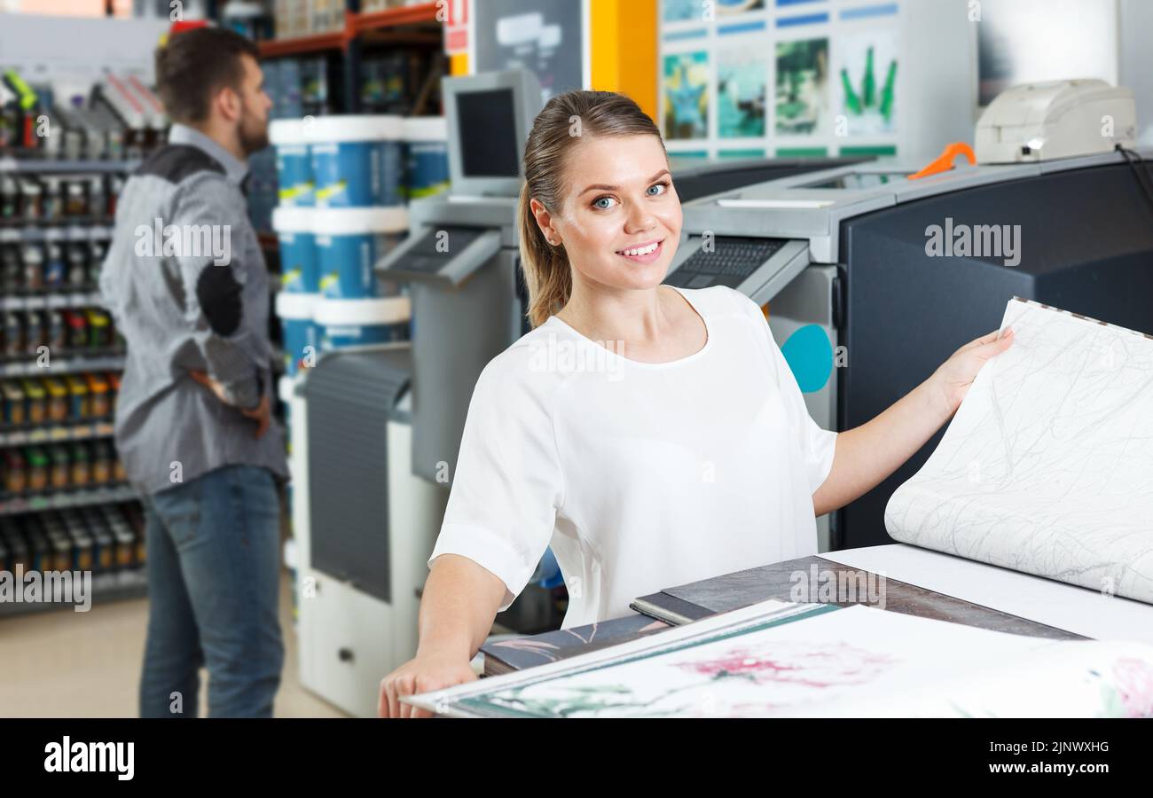Woman looking wallpaper samples in shop Stock Photo - Alamy