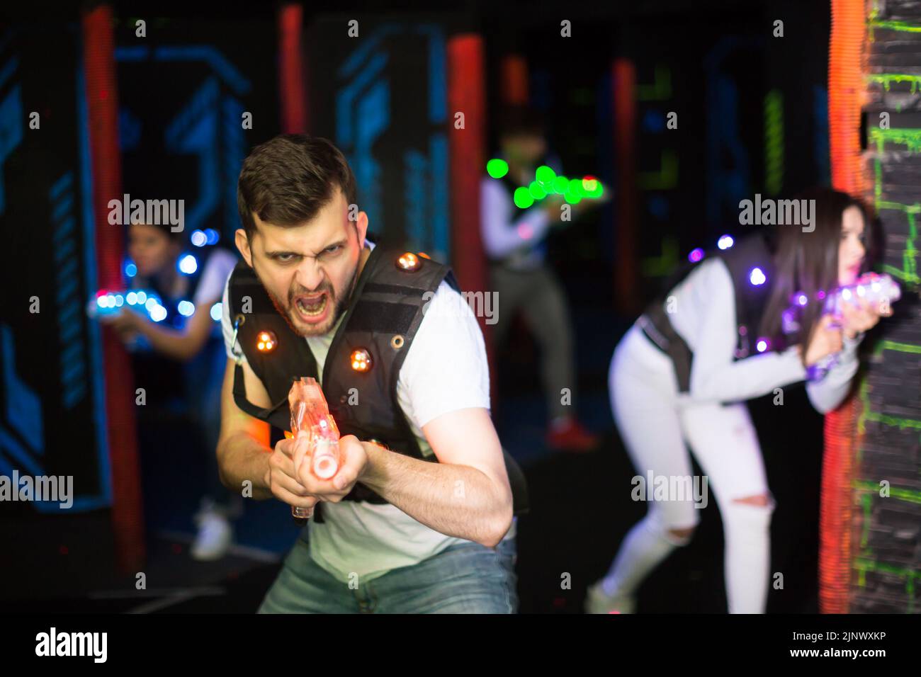 Emotional guy playing laser tag Stock Photo - Alamy
