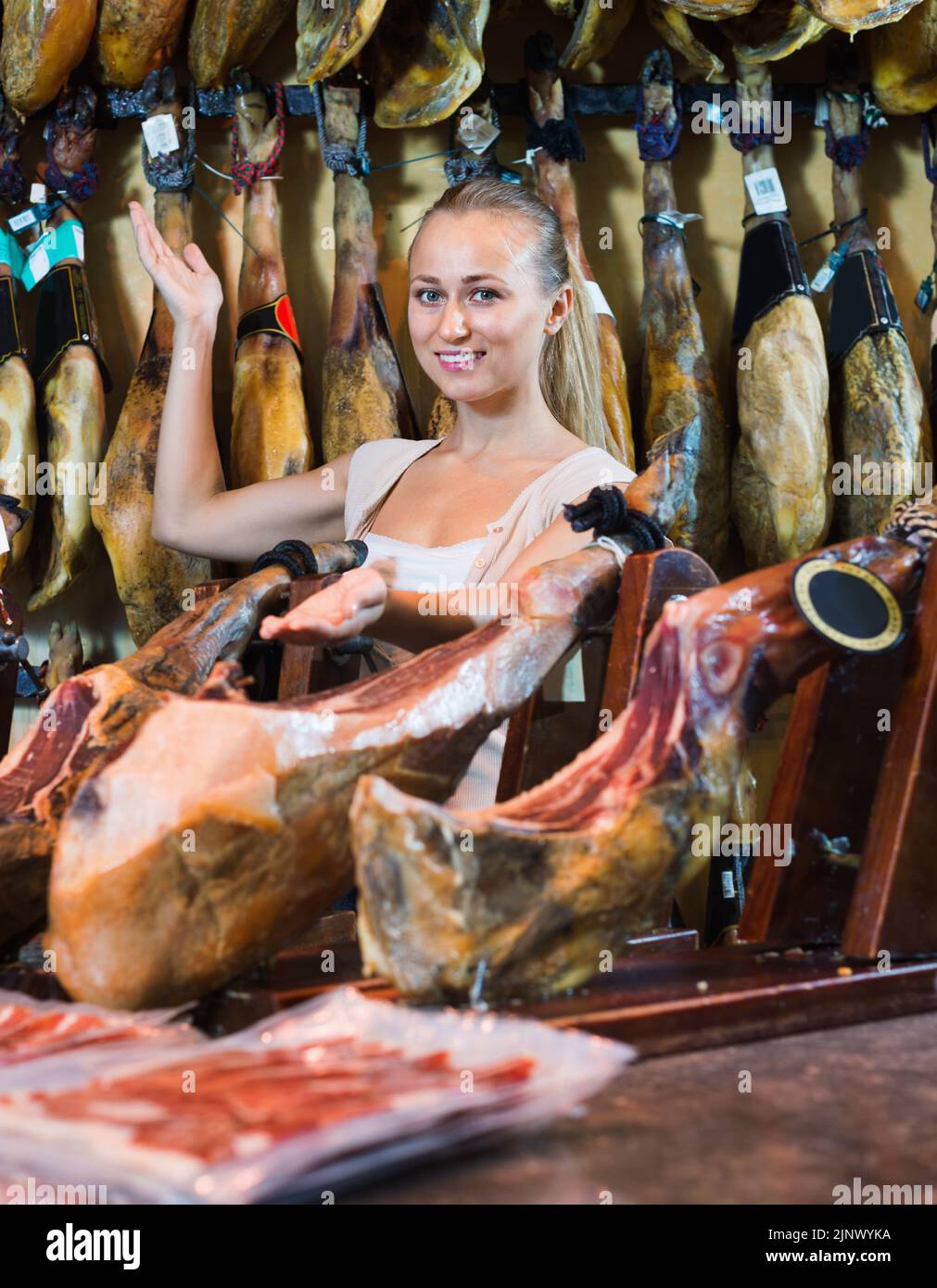 Positive female customer choosing iberian ham Stock Photo - Alamy