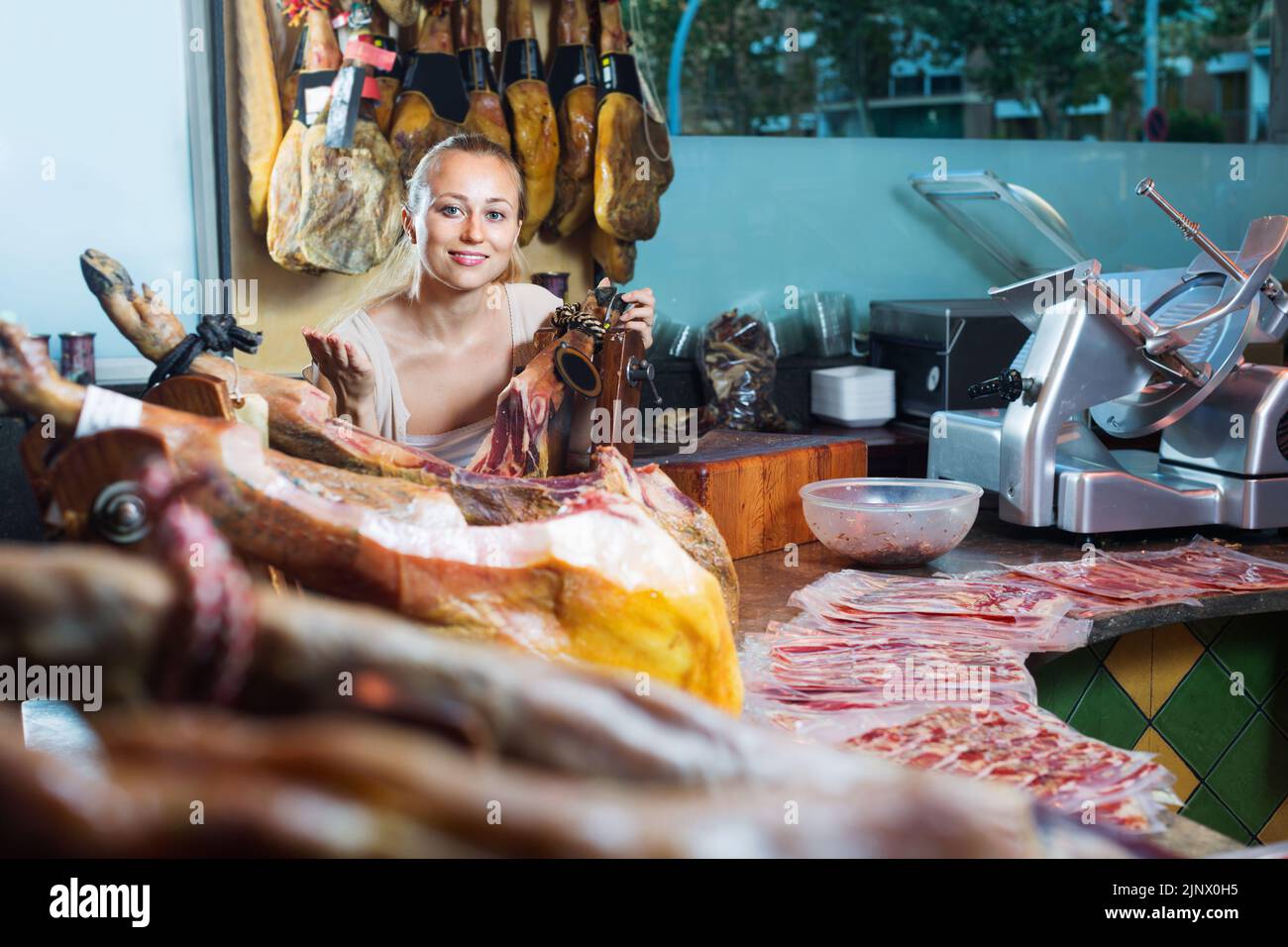 Positive female customer choosing iberian ham Stock Photo - Alamy