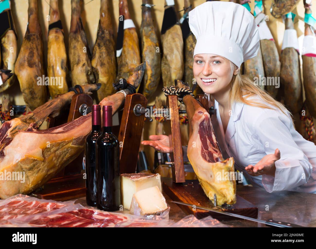 Portrait of glad woman selling prosciutto meat Stock Photo - Alamy
