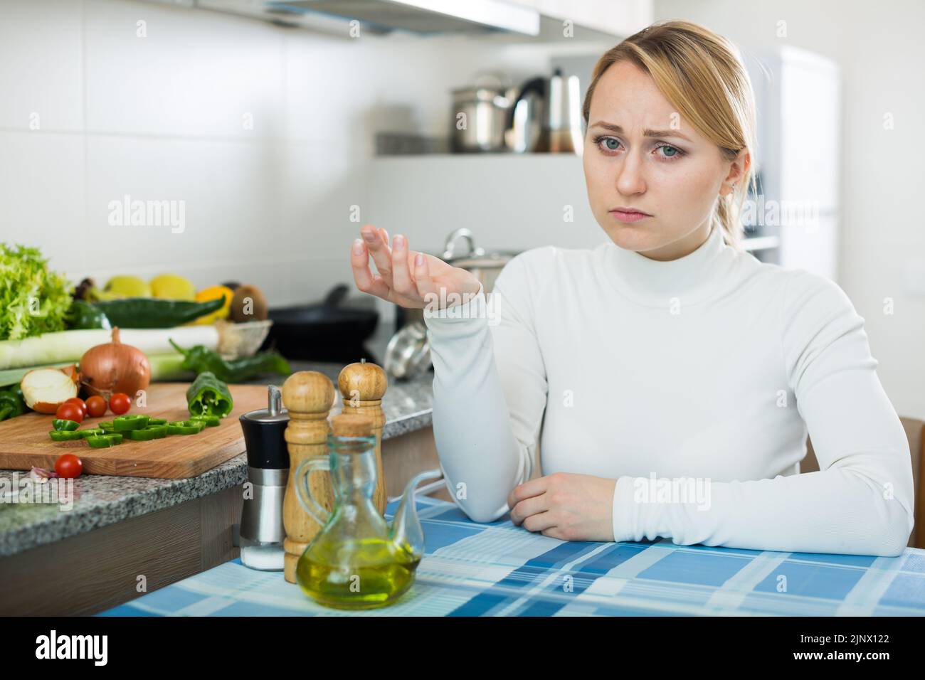 Miserable young woman in domestic kitchen Stock Photo - Alamy