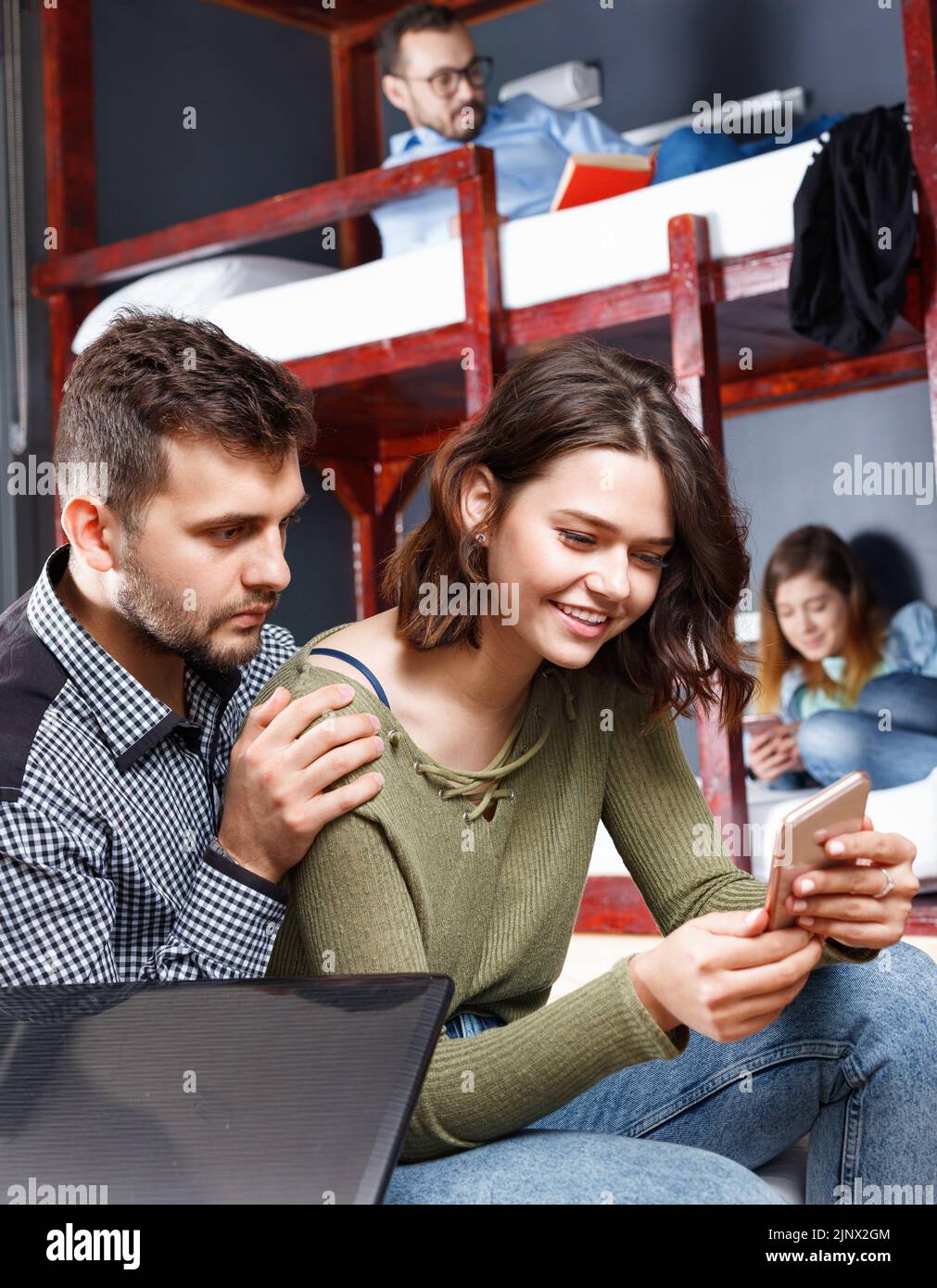 Portrait of young loving couple resting in modern comfy hostel bedroom ...