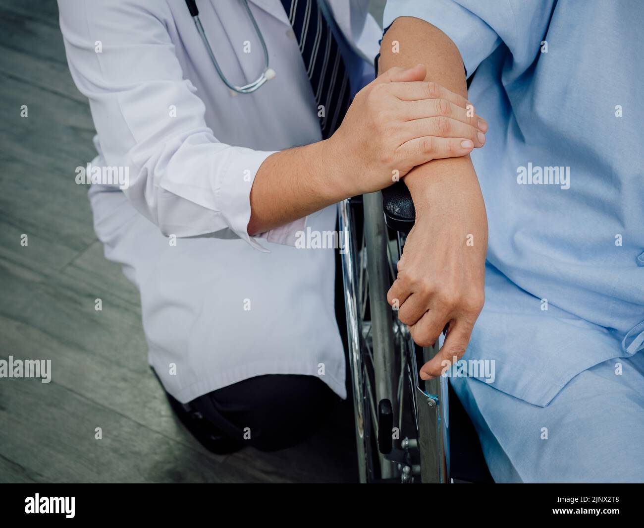 Close Up doctor's hands holding elderly patient 's hand in a wheelchair ...