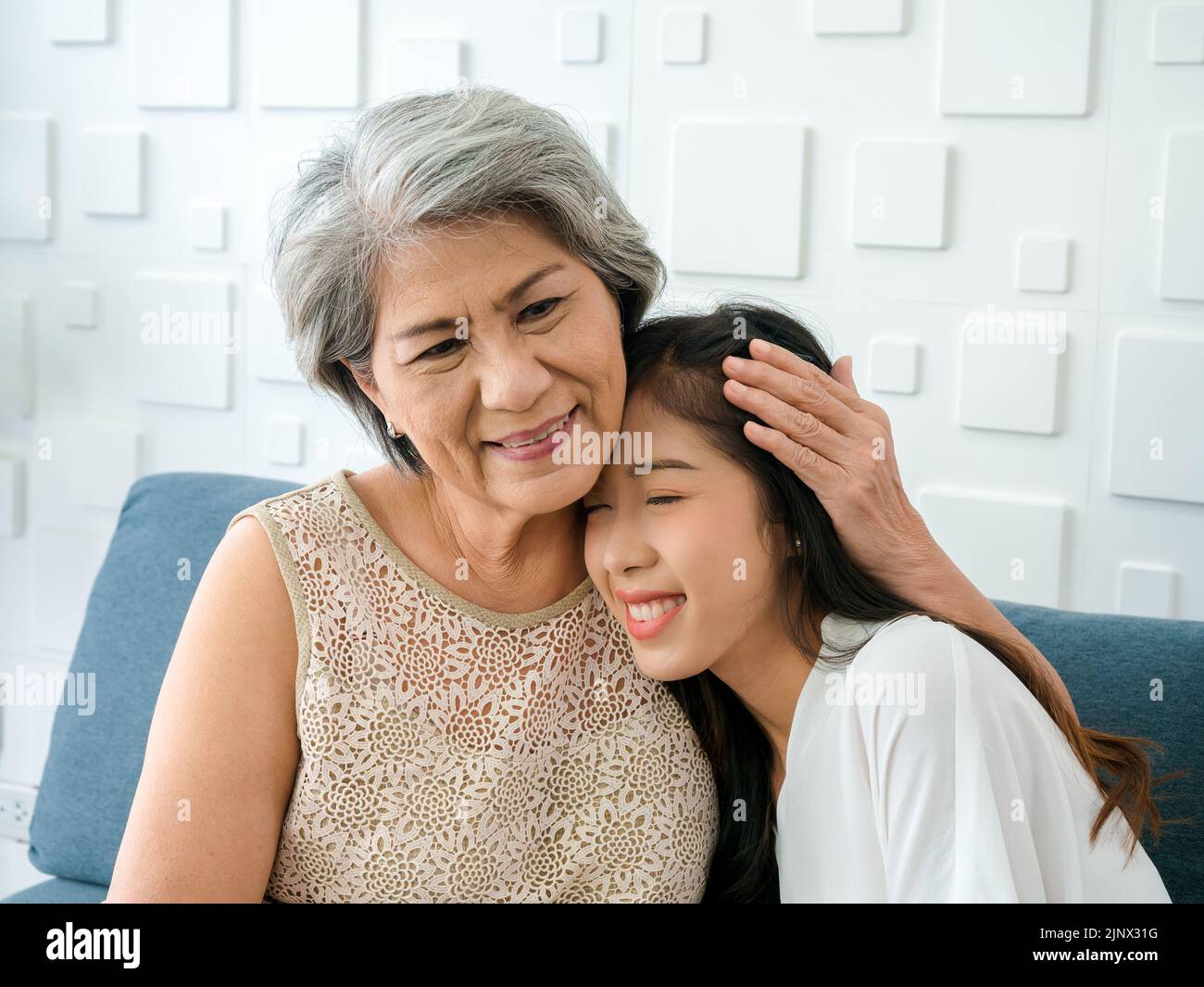 Portrait of happy Asian senior, mother white hair embracing her beautiful daughter with closing ...