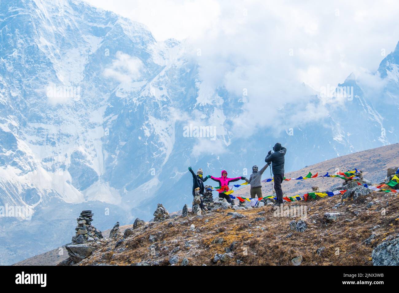 Trekkers and colorful prayer flags on the Everest Base Camp trek in ...