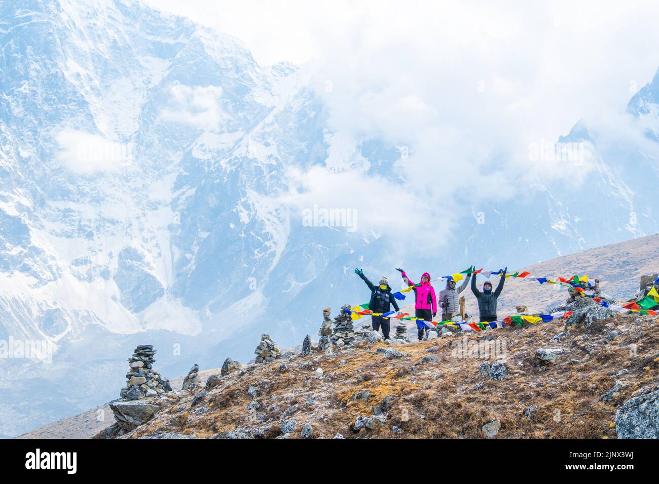 Trekkers and colorful prayer flags on the Everest Base Camp trek in ...