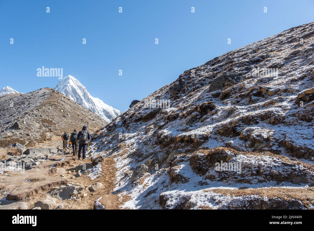 Tourist and porters walking on dirt road in Nepal to Everest Base Camp ...