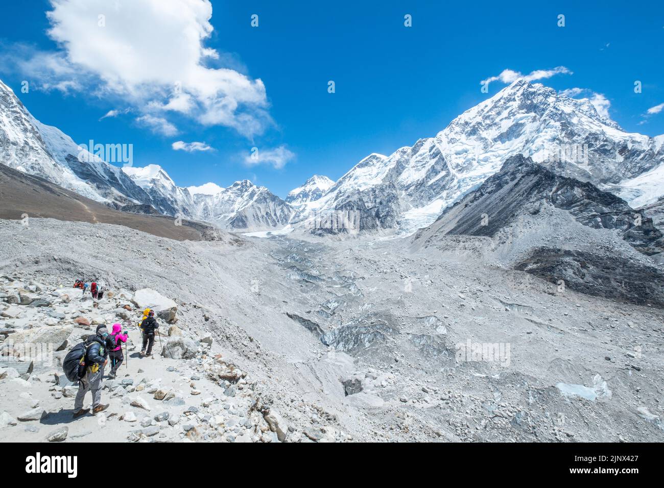 Tourist and porters walking on dirt road in Nepal to Everest Base Camp ...