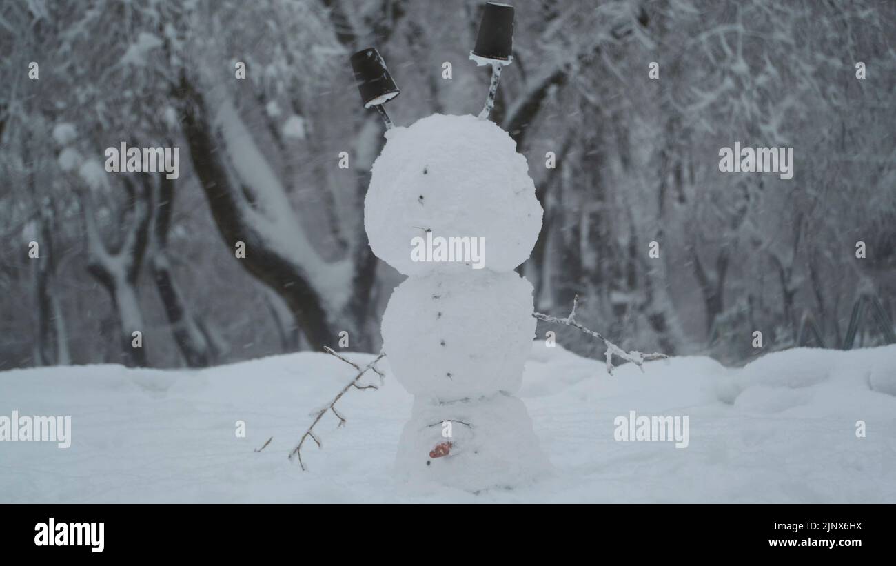 Happy funny snowman acrobat standing on his head, on background of a ...
