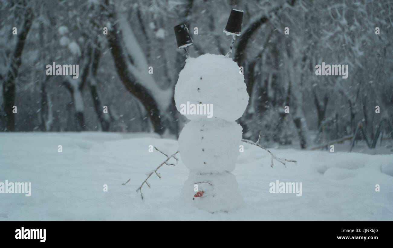 Happy funny snowman acrobat standing on his head, on background of a ...