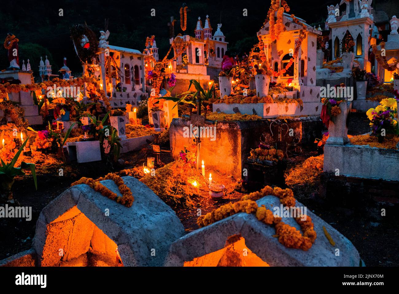 Tombs and graves are seen illuminated by burning candles during the Day ...