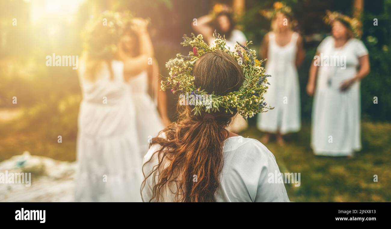 Women in flower wreath on sunny meadow, Floral crown, symbol of summer ...