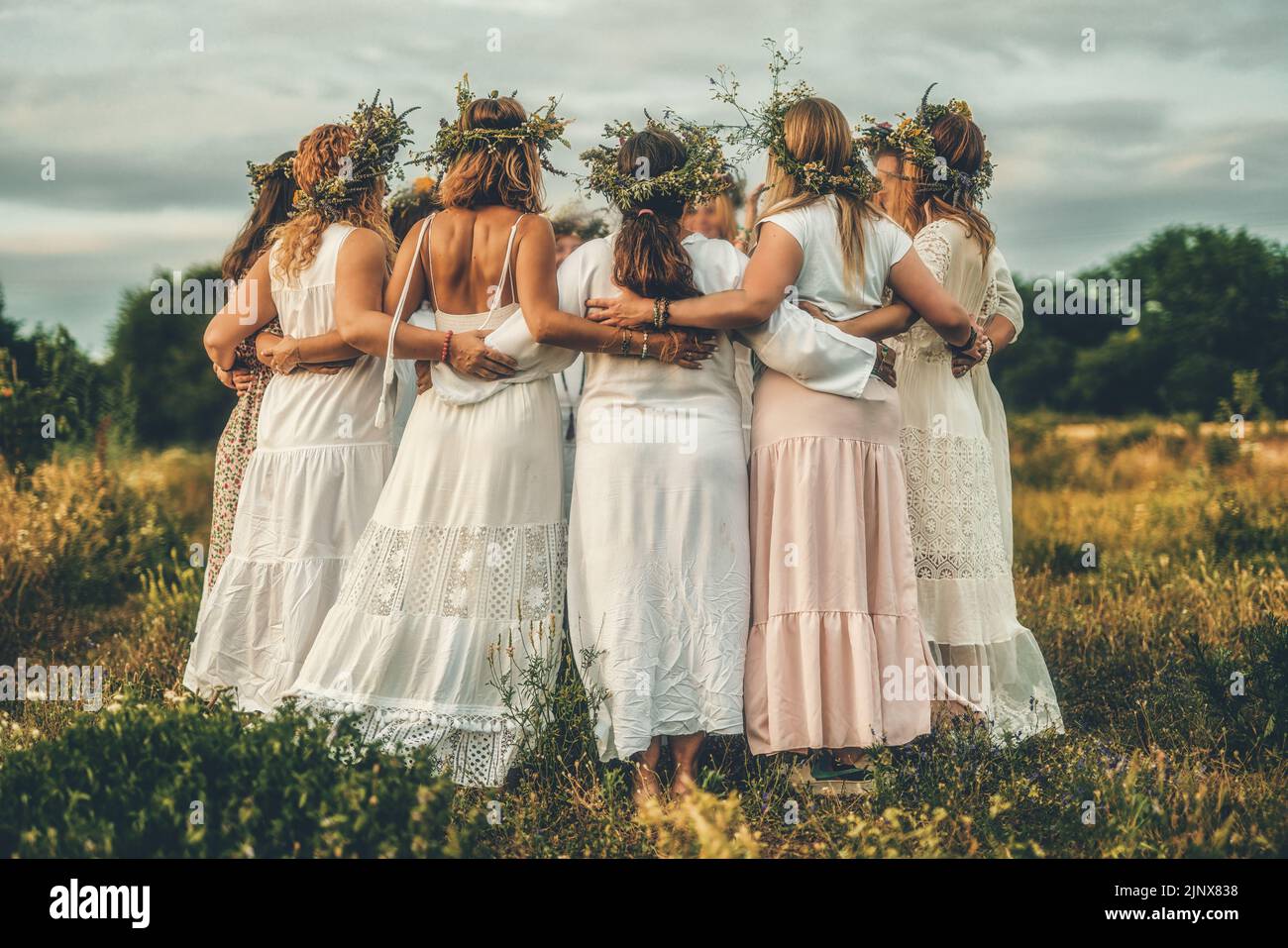 Women in flower wreath on sunny meadow, Floral crown, symbol of summer ...