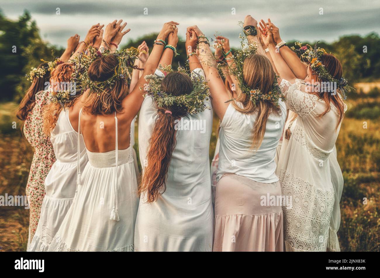 Women in flower wreath on sunny meadow, Floral crown, symbol of summer ...