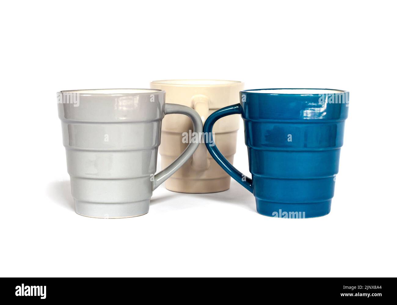 Three mugs with handles turned one to the other, isolated on white ...