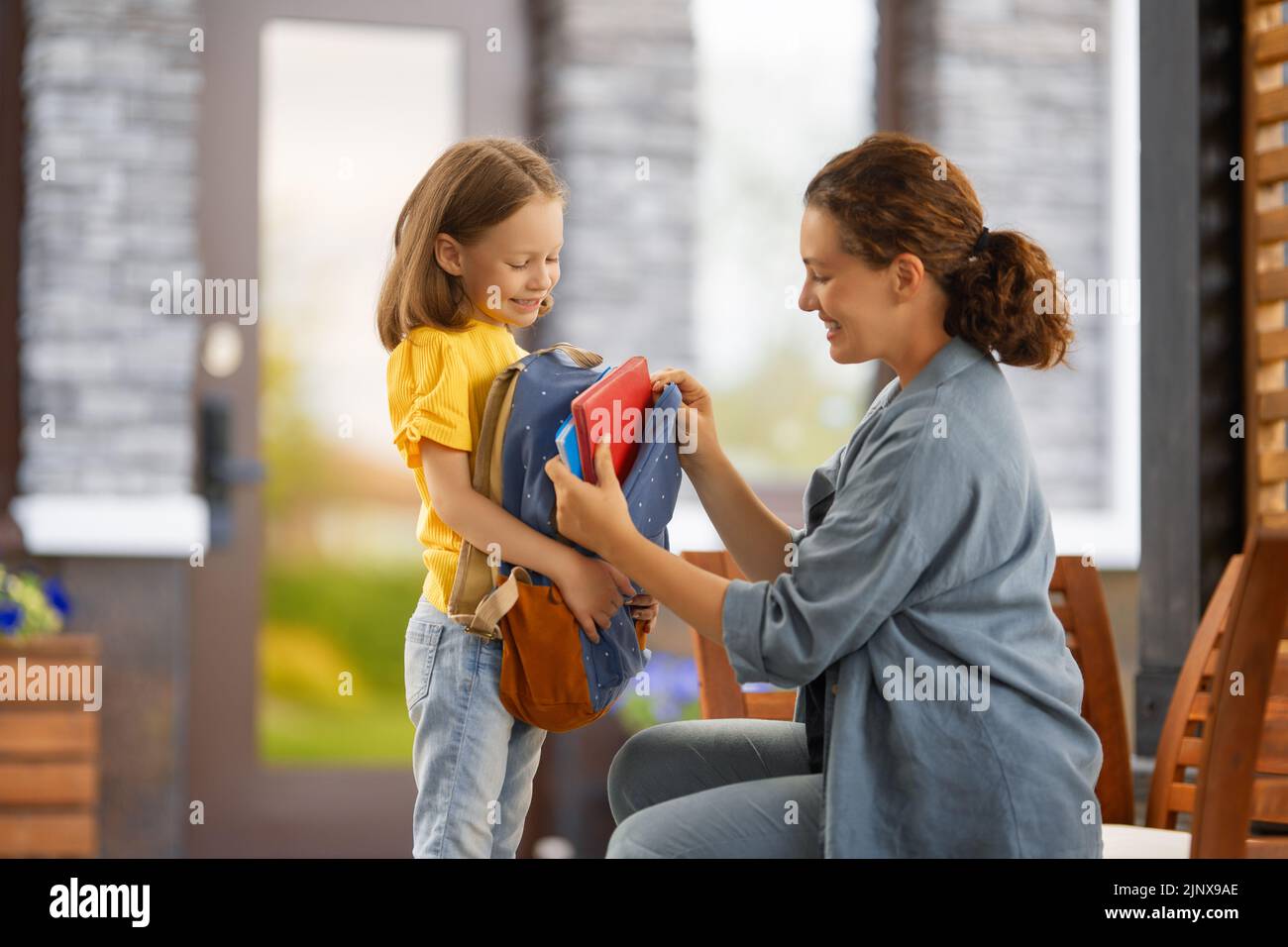 Parent and pupil of primary school going hand in hand. Woman and girl ...