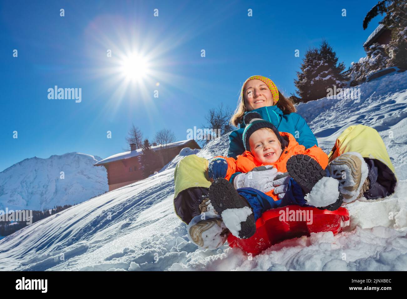 Mother with little boy together sit in the sledge go downhill Stock ...