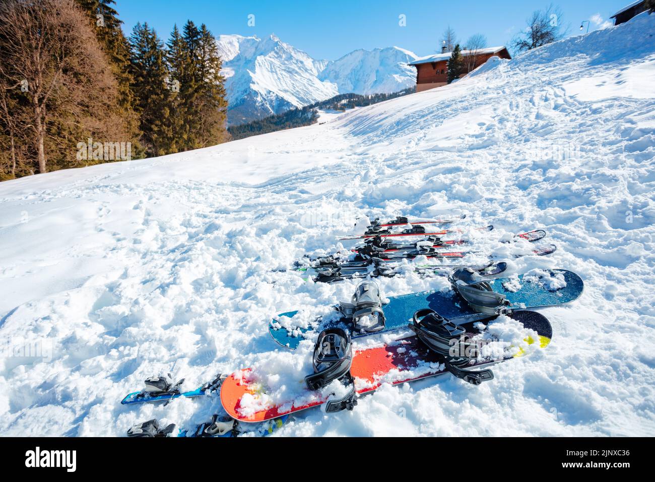 Skis and snowboard lay in the snow on a slope Stock Photo - Alamy
