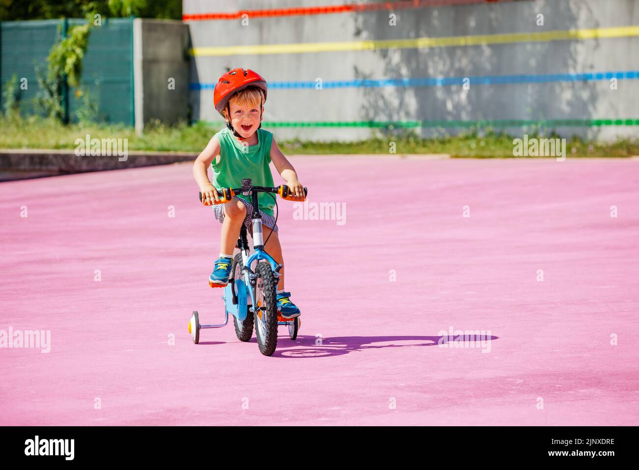 Boy ride small bicycle with learning wheels on color surface Stock ...
