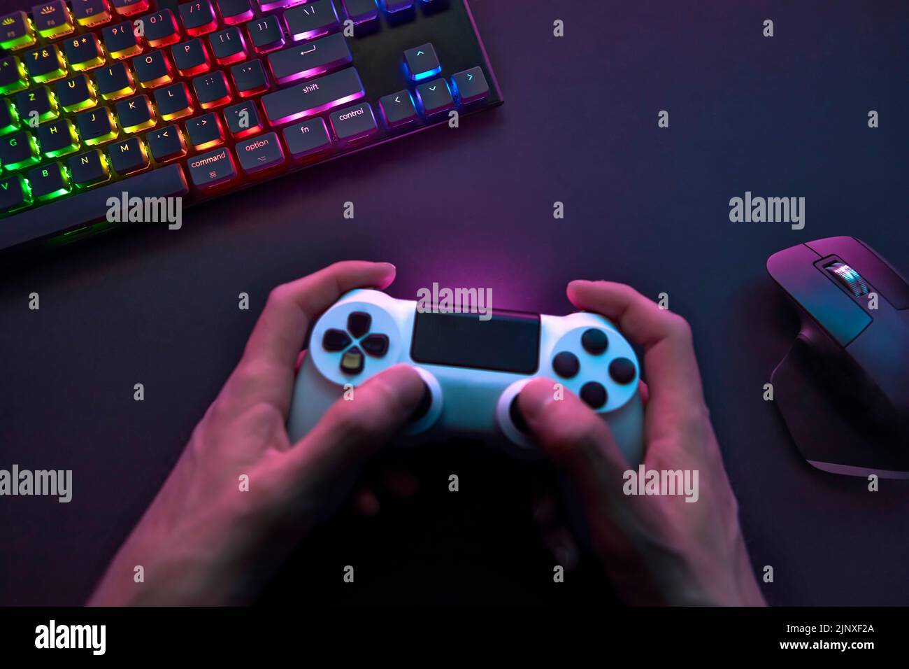 High angle view of male hand using game controller above dark desk with ...