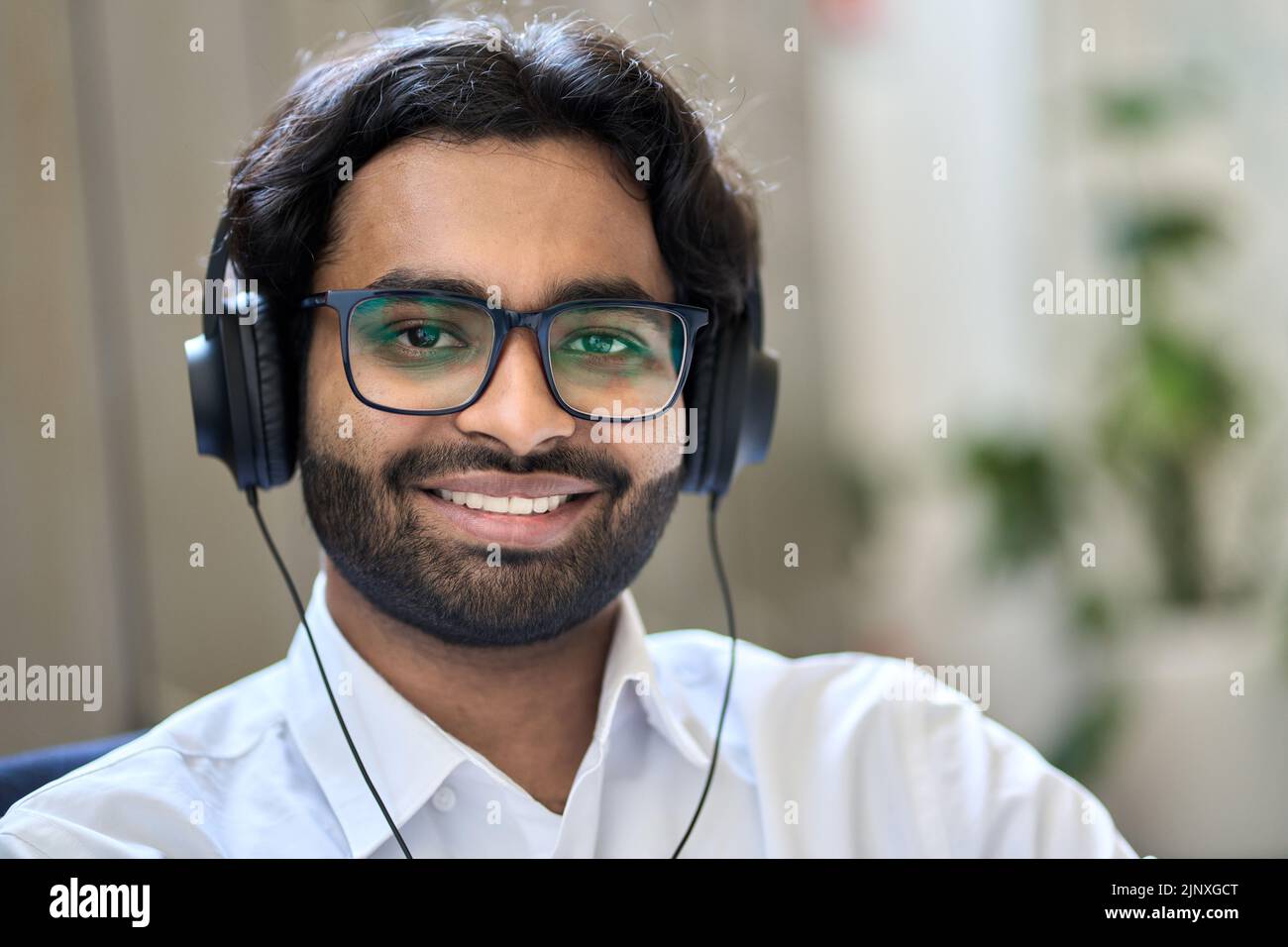 Smiling indian business man wears headphones looks at camera, headshot portrait Stock Photo - Alamy